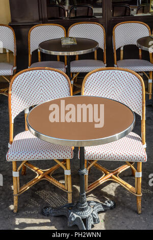 A small table and chairs set up outside a restaurant in the winter snow ...