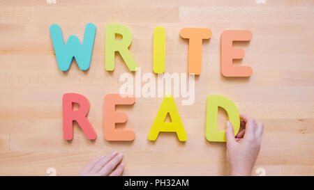Words READ and WRITE from multicolor wooden letters on wooden table ...