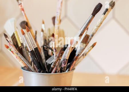 Different brushes of the artist in a metal bucket, selective focus ...