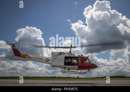 A 413th Flight Test Squadron UH-1 Huey lifts off from the flightline at ...