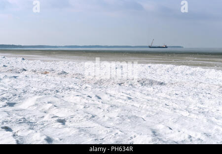 ice sludge in the sea, oil platform in the winter sea on the horizon ...