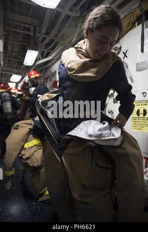 US Navy A Sailor dons his firefighting gear during flight quarters.jpg ...