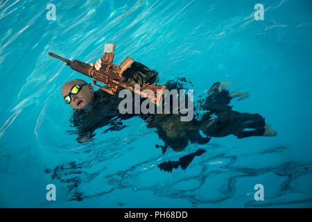 A U.S. Marine swims with his pack during swim qualification on Camp H.M ...