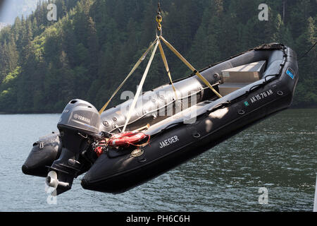 Empty DIB/zodiac inflatable boat being lifted up to the upper deck on ...