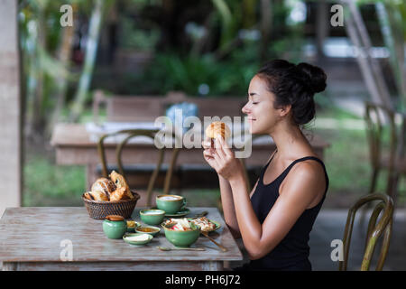 Young woman eat breakfast with knife and fork, Morning in cafe. Healthy ...