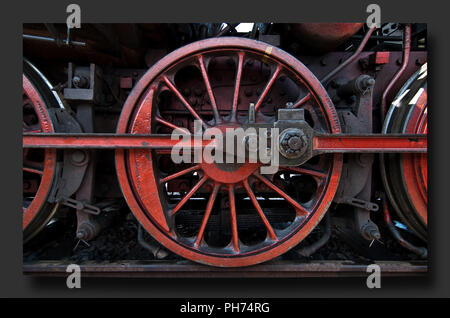Red frame and wheels of a steam locomotive with cranks, rods and axles ...