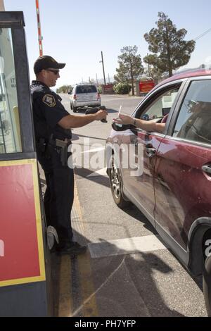 A police officer checks the identification card of a woman attempting ...