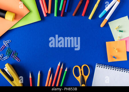 top view of arranged variety pencils and blank textbook on blue ...