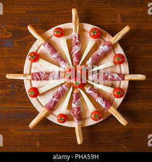 square wooden cutting board with cherry tomatoes, cheese and spices on ...