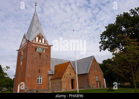 Medieval danish brick church with blue sky and green trees, Tirsted ...