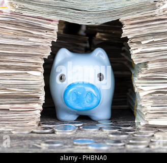 Blue old piggy bank with coins on a wooden table Stock Photo - Alamy