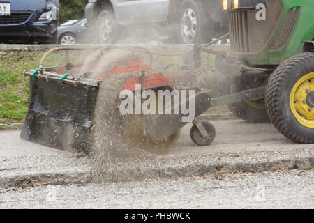 Cleaning the pavement of chippings with a sweeper Stock Photo - Alamy