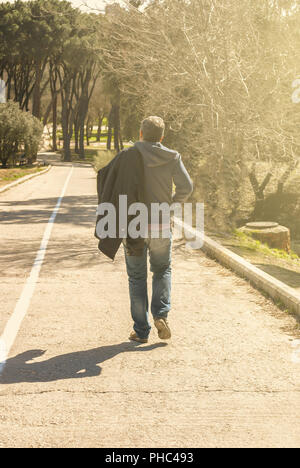 Back view of a man walking into the distance. Lower body shot Stock ...