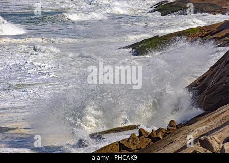 Strong wave breaking over rocks with water splashing in the air Stock ...