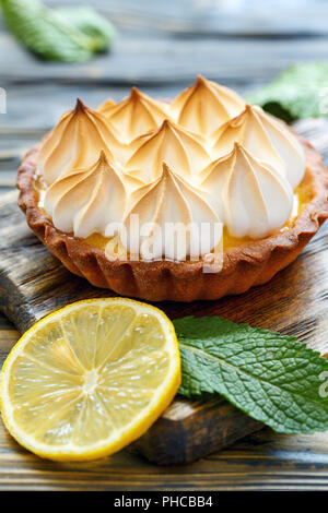 Tartlet with Italian meringue and lemon cream on a wooden stand ...