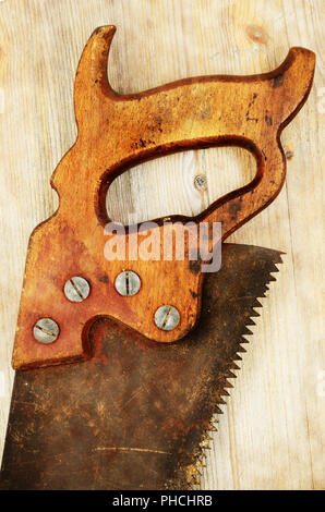 old rusty saw on wooden background Stock Photo - Alamy