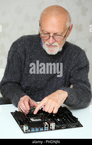 male technician repairing motherboard at table indoors Stock Photo - Alamy