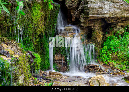 Holy springs in Izborsk. A small waterfall in Russia. Descent of water ...