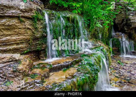 Holy springs in Izborsk. A small waterfall in Russia. Descent of water ...