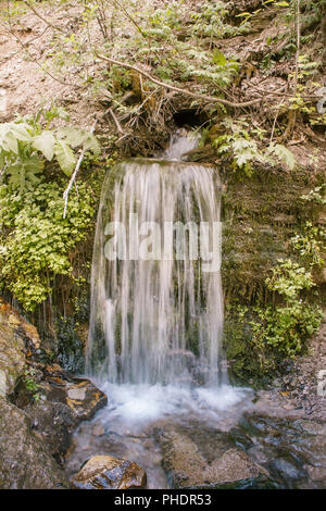 Holy springs in Izborsk. A small waterfall in Russia. Descent of water ...