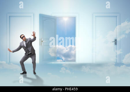 Confused businessman in front of doors Stock Photo - Alamy