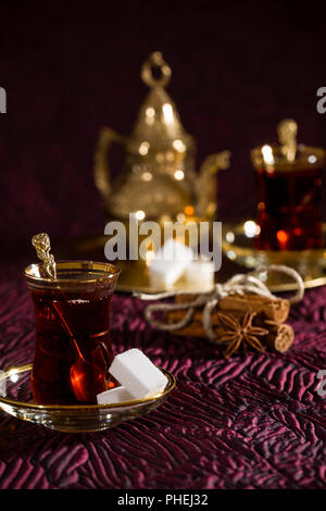 Tray with glass of Turkish tea, anise stars, dried dates and sugar ...
