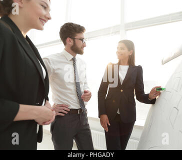 businesswoman pointing marker to flipboard on presentation in office ...
