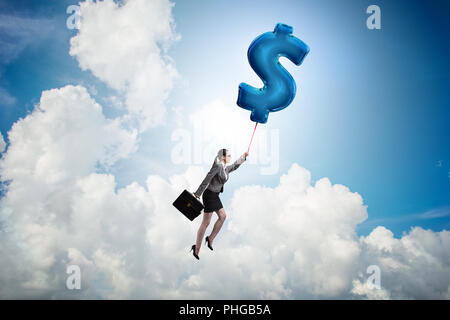 Businesswoman flying on dollar sign inflatable balloon over financials ...