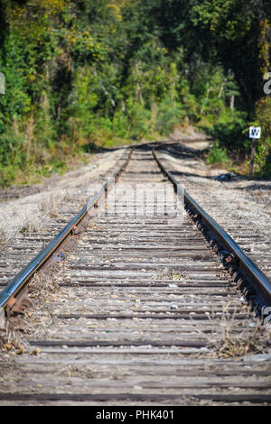 Perspective view of empty train tracks and concrete platform under ...