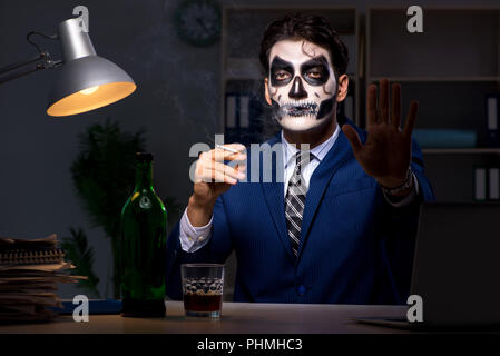 Businessman with scary face mask working late in office Stock Photo - Alamy