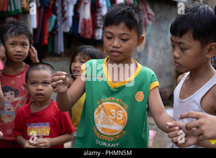 Filipino children partaking in the popular game of spider fighting ...