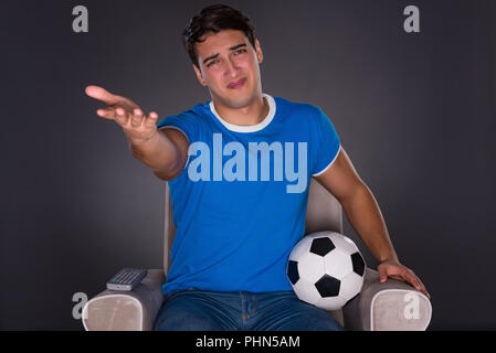 Man watching sports on gray background Stock Photo - Alamy