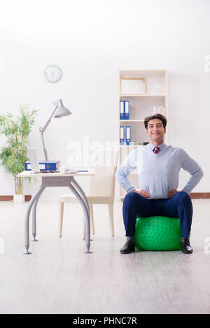 Employee exercising with swiss ball during lunch break Stock Photo - Alamy