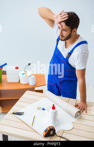 Worker working on wallpaper during refurbishment Stock Photo - Alamy