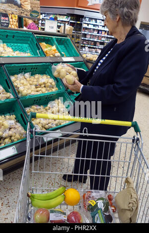 Elderly lady supermarket shopping at a Morrisons supermarket aisle ...