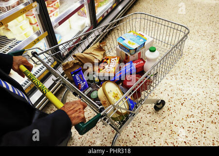 Elderly lady supermarket shopping at Morrisons supermarket aisle ...
