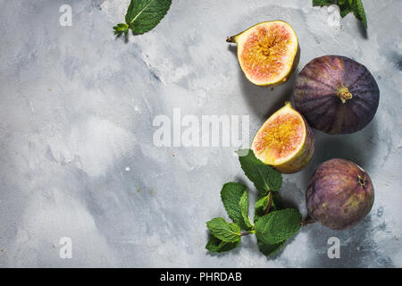 Top view of a group of green figs on a white table and metallic knife ...
