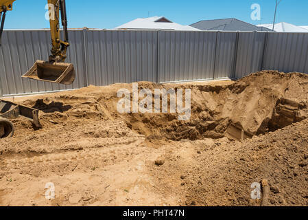 An excavator digging a swimming pool Stock Photo - Alamy