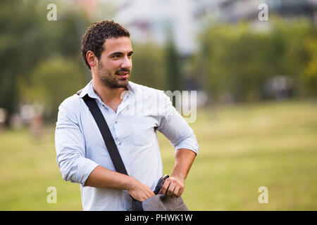 Cheerful man searching for something, looking through magnifying glass ...