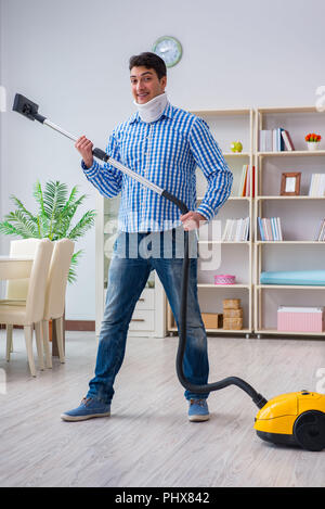 Injured man with neck injury vacuum cleaning house Stock Photo - Alamy