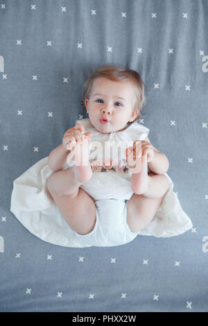 From above of adorable girl in protective helmet looking at camera ...
