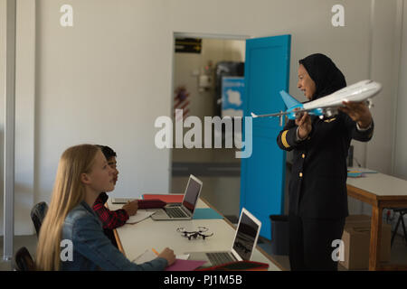Female pilot teaching about model plane to kids Stock Photo - Alamy