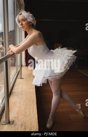 Ballerina looking through window in dance studio Stock Photo - Alamy
