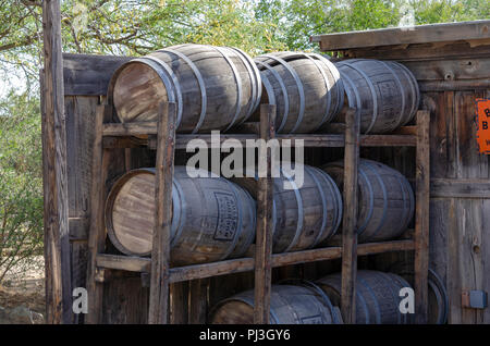 Wooden barrels stacked on a wooden shelf with a lantern on a wooden ...