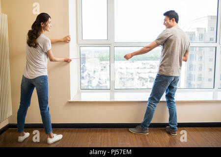 Young couple measuring window Stock Photo - Alamy