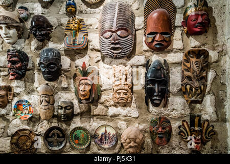 African wooden painted masks hanging on a wall beneath an Arabesque ...