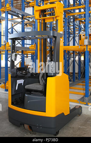 Yellow high rack stacker forklift in warehouse Stock Photo - Alamy
