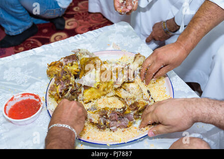 Abu Dhabi, UAE - July 26, 2018: Hands of a group of Arabic men reaching ...