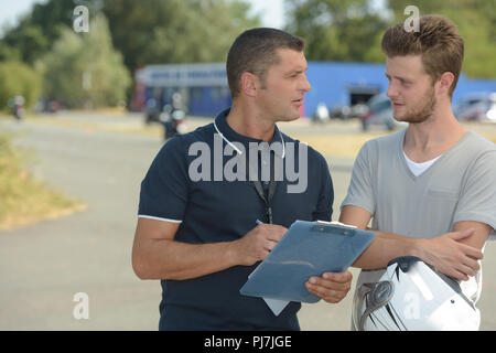 student driver with instructor filling forms before driving test Stock ...