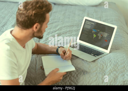 Handsome male student doing task Stock Photo - Alamy